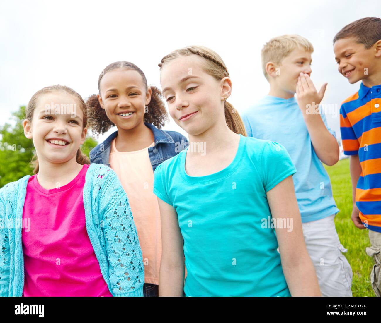 Friends make growing up easier. A multi-ethnic group of kids standing ...