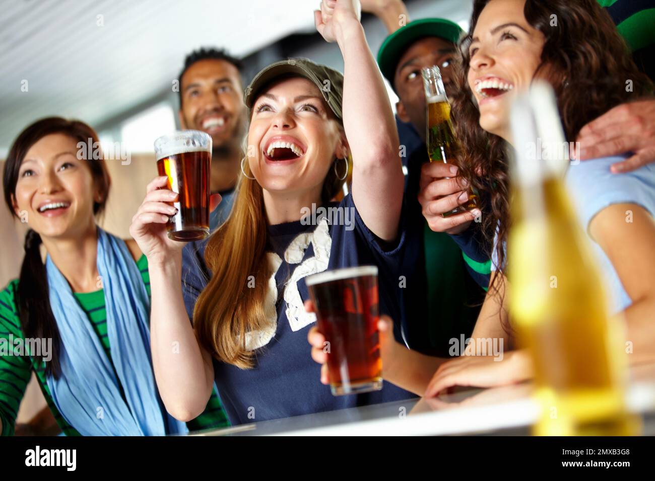 Drinks and sports with friends. A group of excited friends cheering on ...