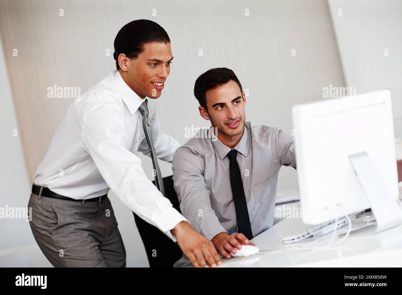 You work is looking great. A helpful businessman aiding a colleague ...