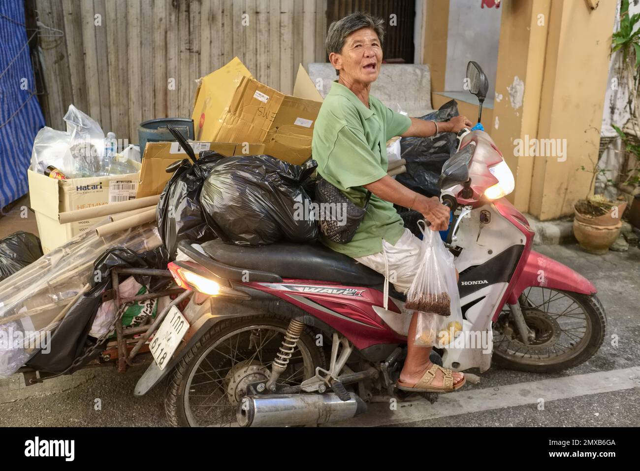 A very cheerful trash collector in Phuket Town, Thailand, a well-known ...