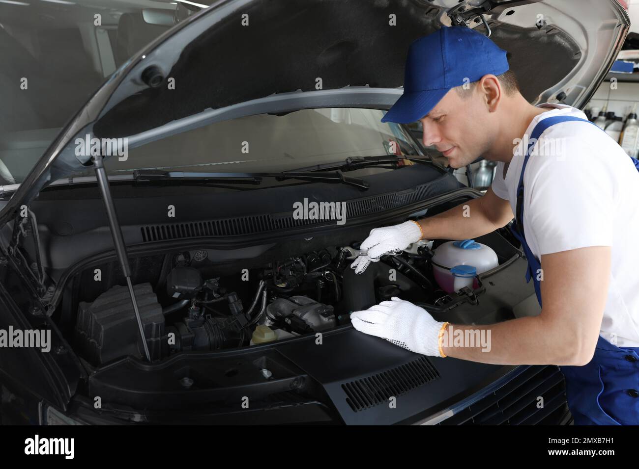 Professional auto mechanic fixing modern car in service center Stock ...