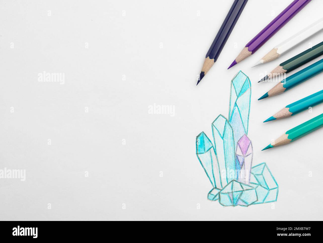 Drawing of crystals and colorful pencils on white background, top view ...