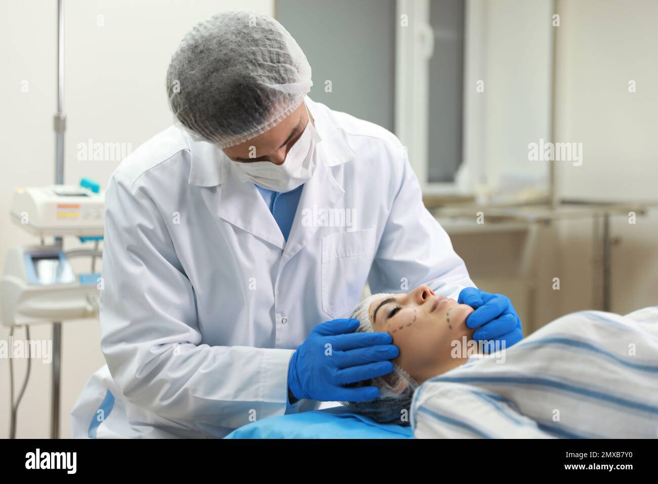 Doctor preparing female patient for cosmetic surgery in clinic Stock ...