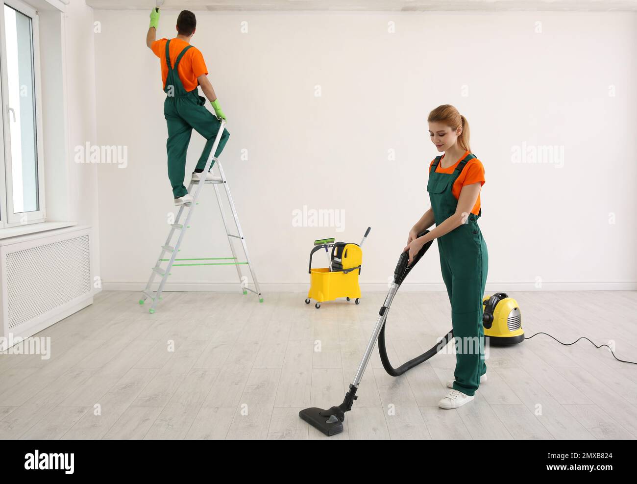 Professional young janitor vacuuming hi-res stock photography and ...