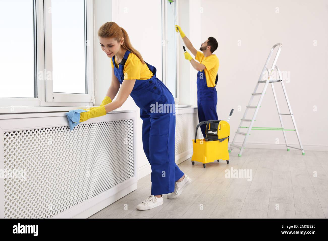 Professional janitors in uniform cleaning spacious room Stock Photo - Alamy