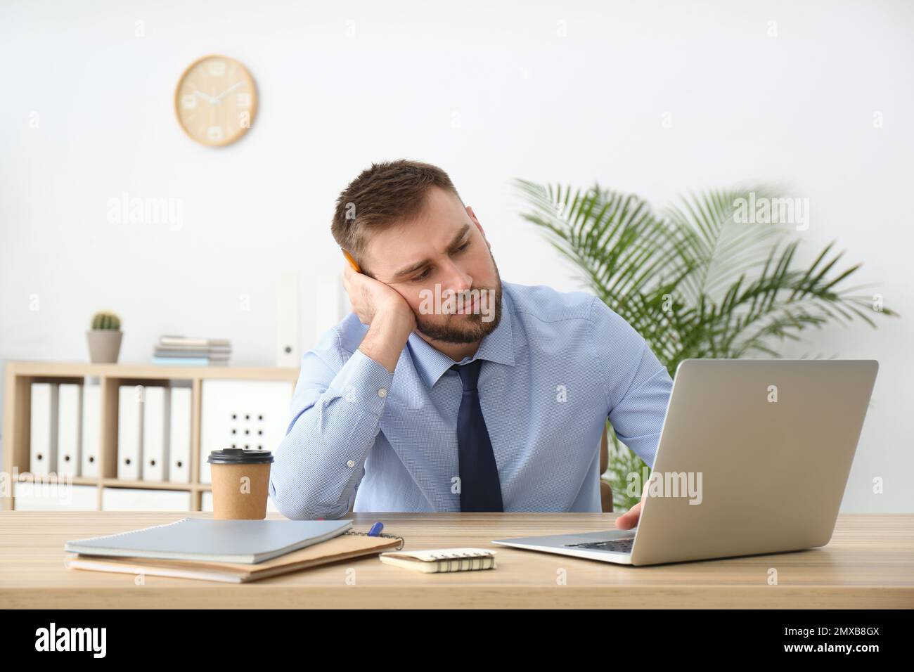 Lazy young office employee procrastinating at workplace Stock Photo - Alamy