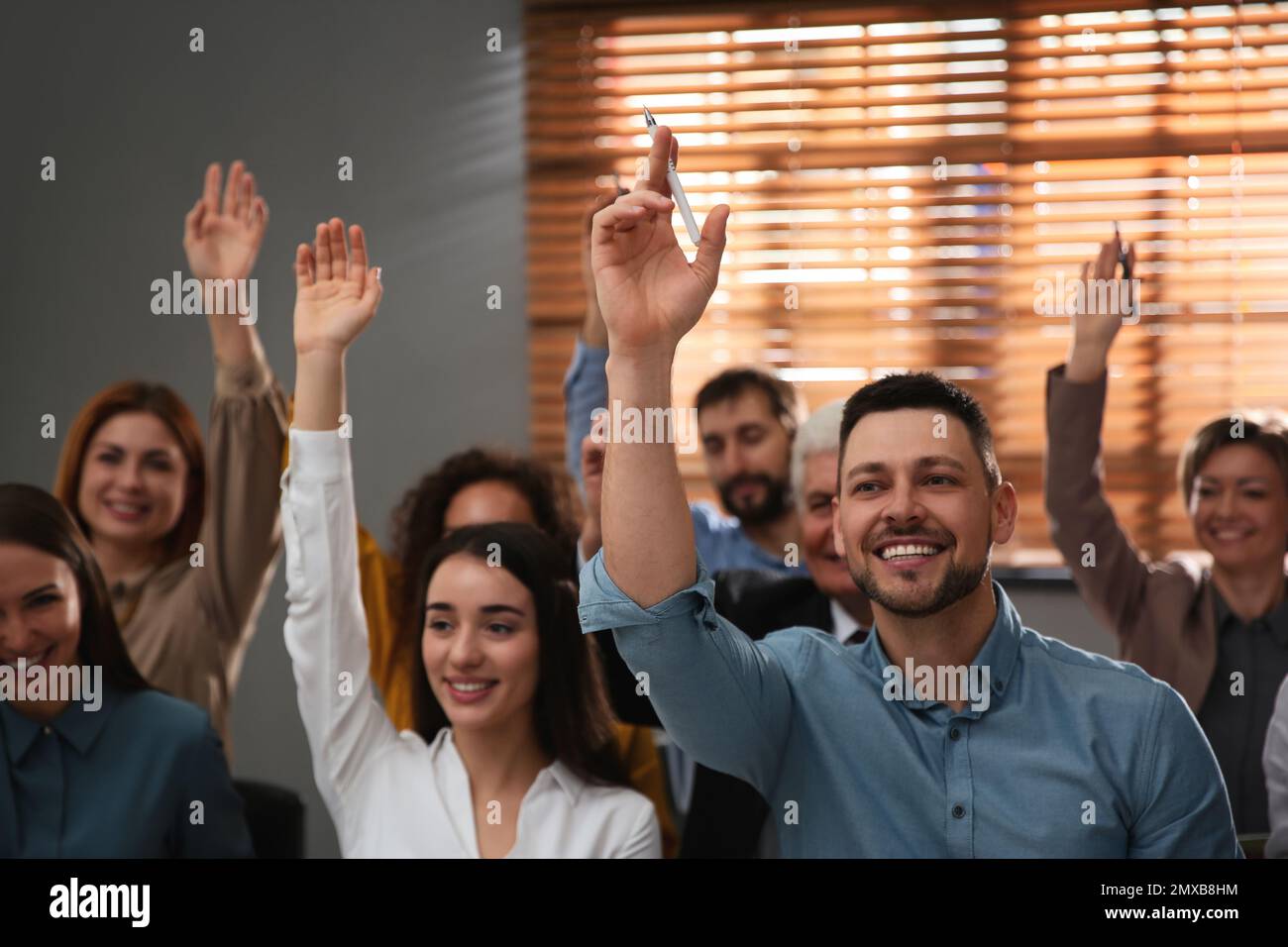 People raising hands to ask questions at seminar in office Stock Photo ...