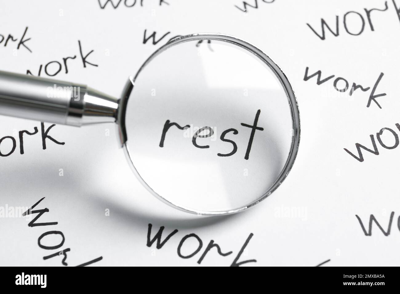 Magnifying glass above sheet of paper with words REST and WORK. Search ...