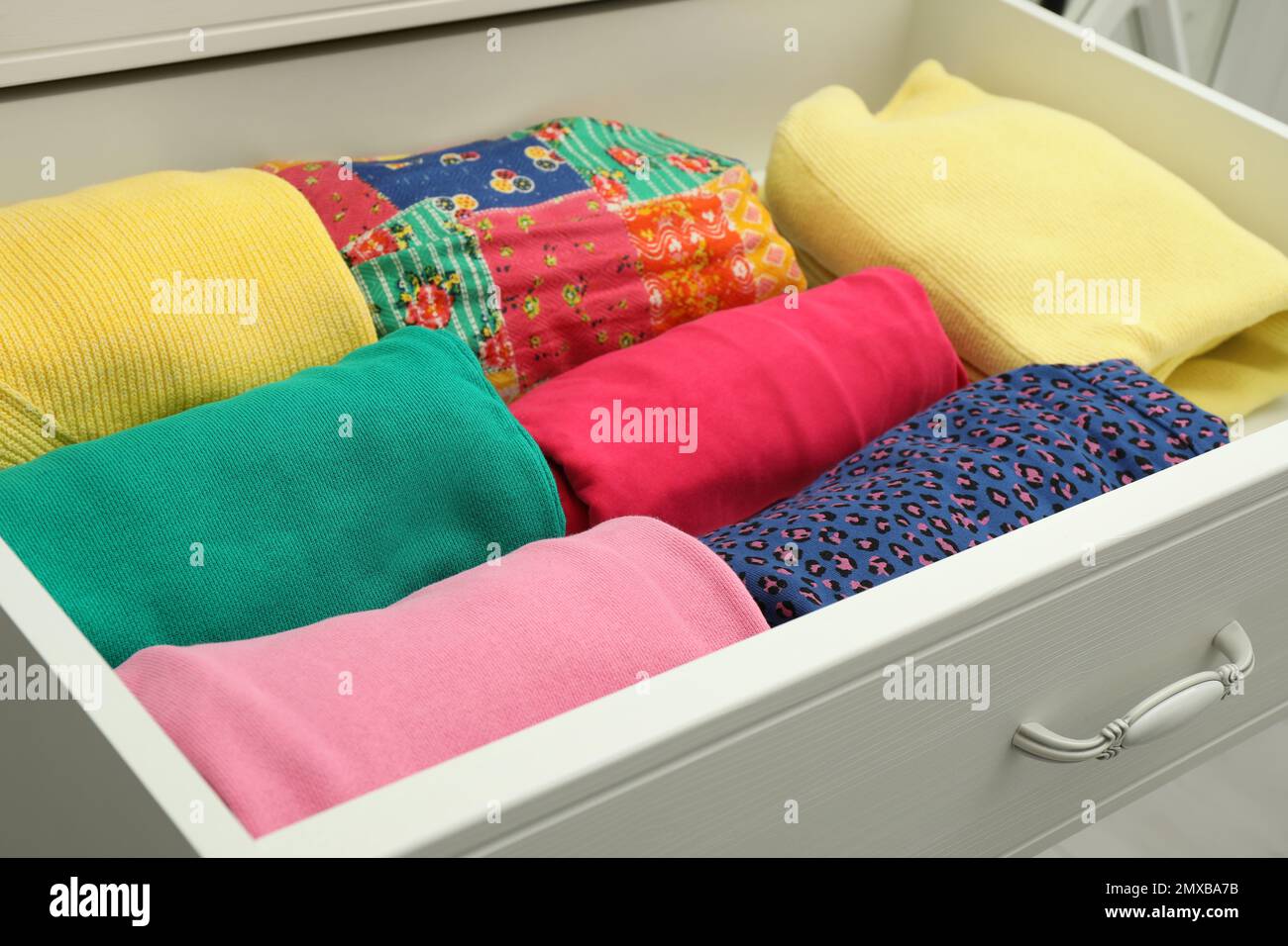 Folded clothes in open drawer. Apparel storage Stock Photo - Alamy