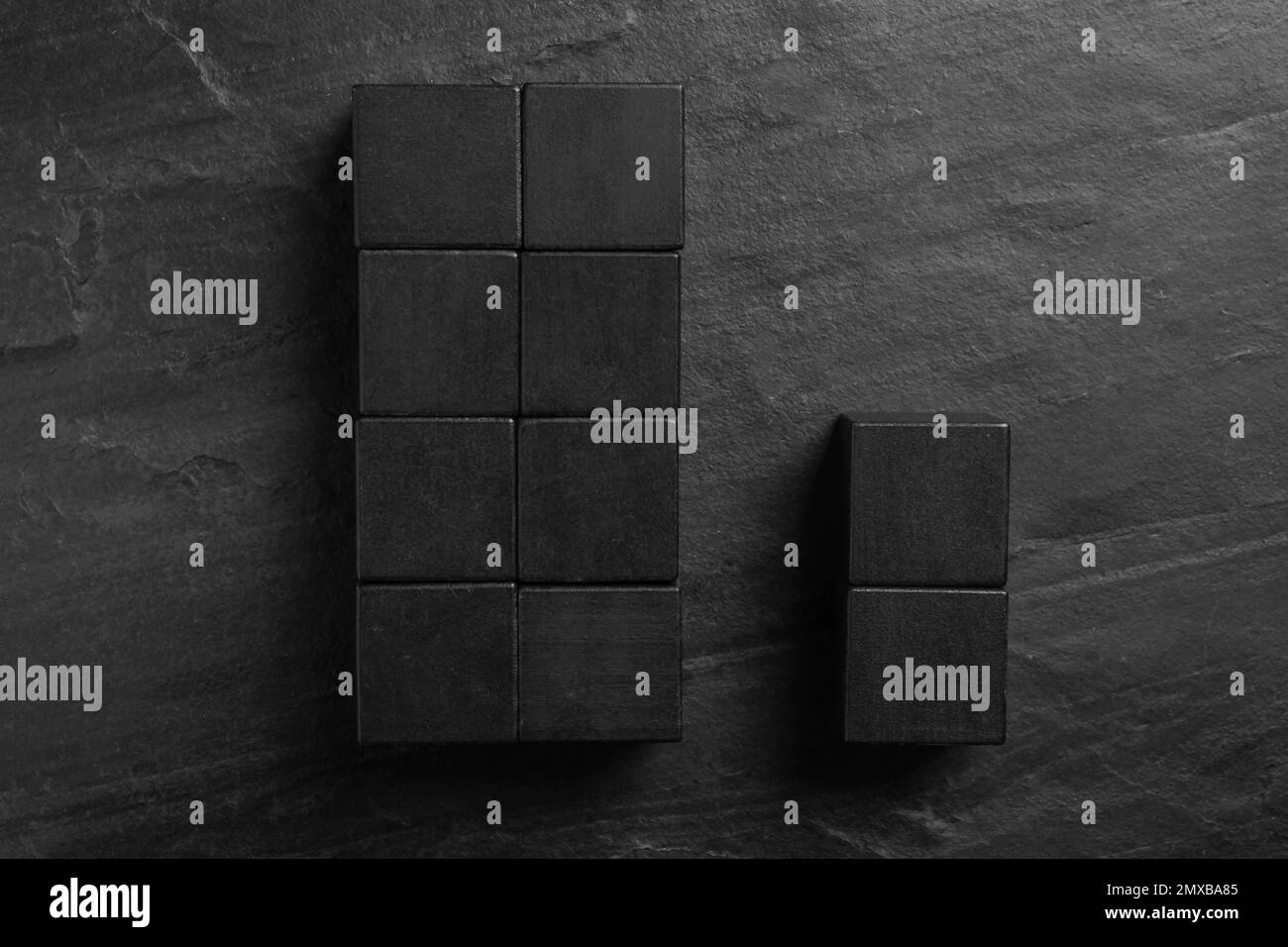 Flat lay composition with cubes on black slate background. Pareto ...