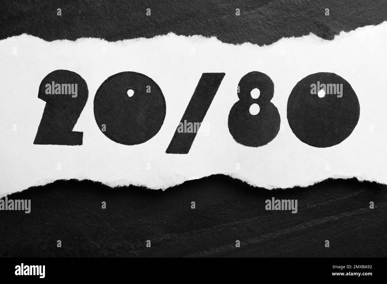 Sheet of paper with numbers 20 and 80 on black slate background, top ...