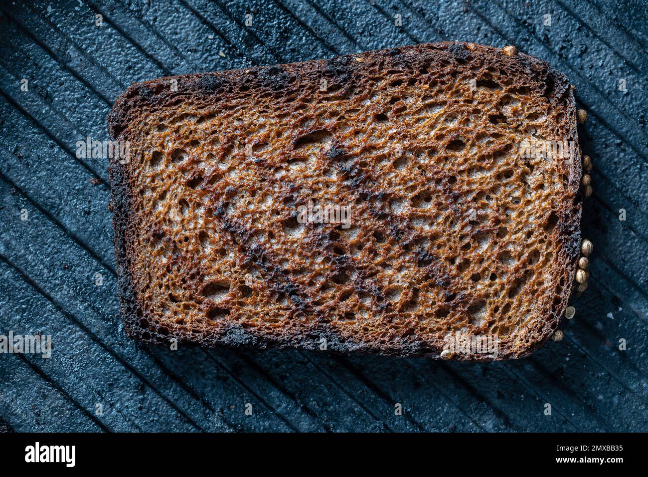 Deep fried toast bread on a black cast-iron grill pan, close-up, top ...
