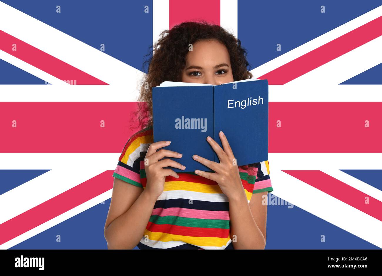 Beautiful African-American girl with book and flag of Great Britain as ...