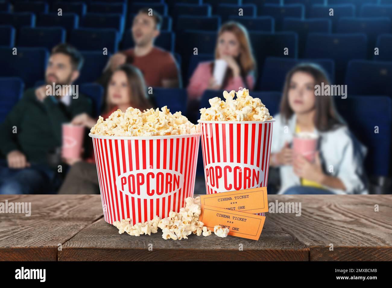 Popcorn, tickets on table and young people in cinema hall Stock Photo ...