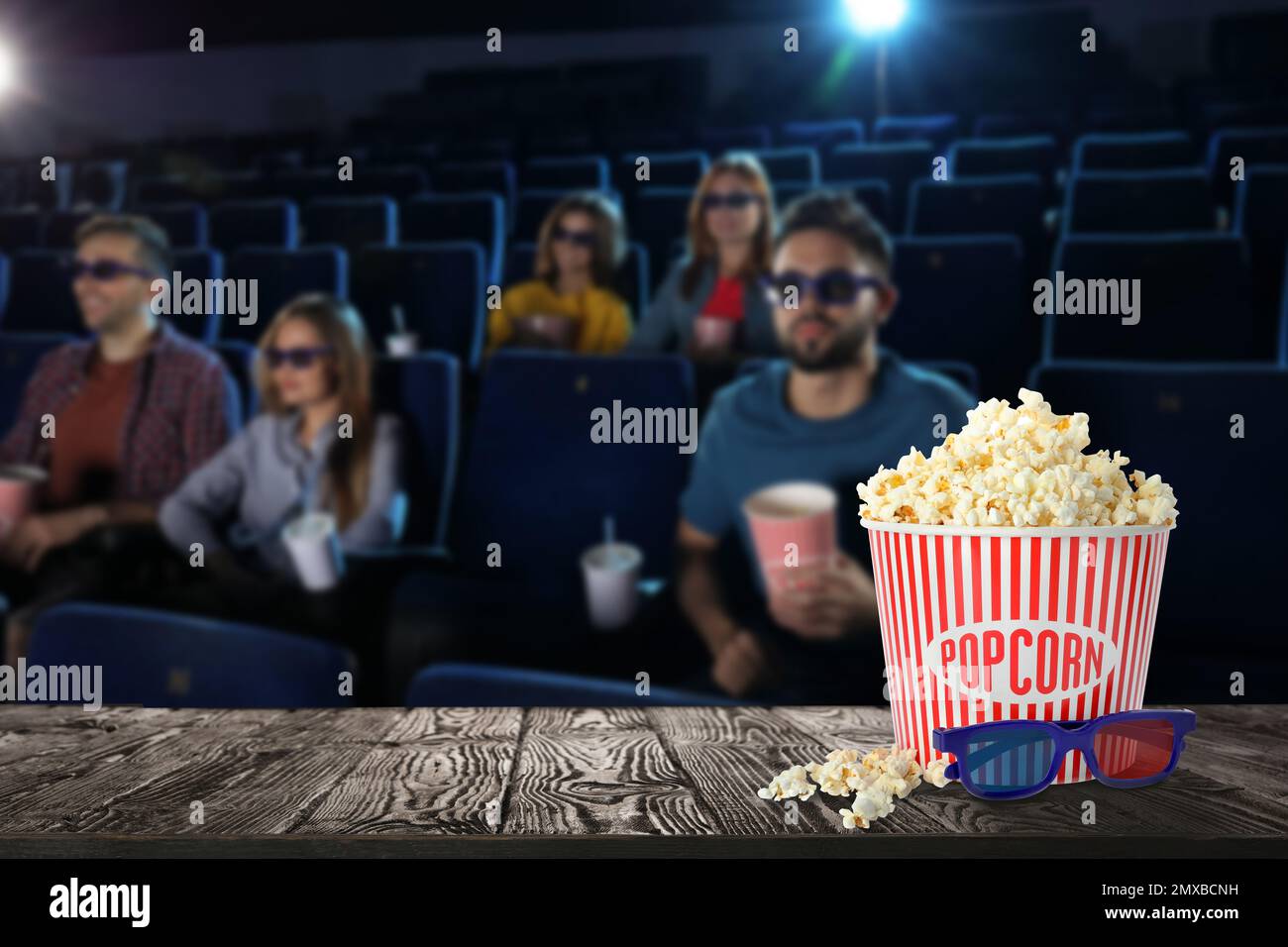 Popcorn, 3D glasses on table and young people in cinema hall, space for text Stock Photo - Alamy