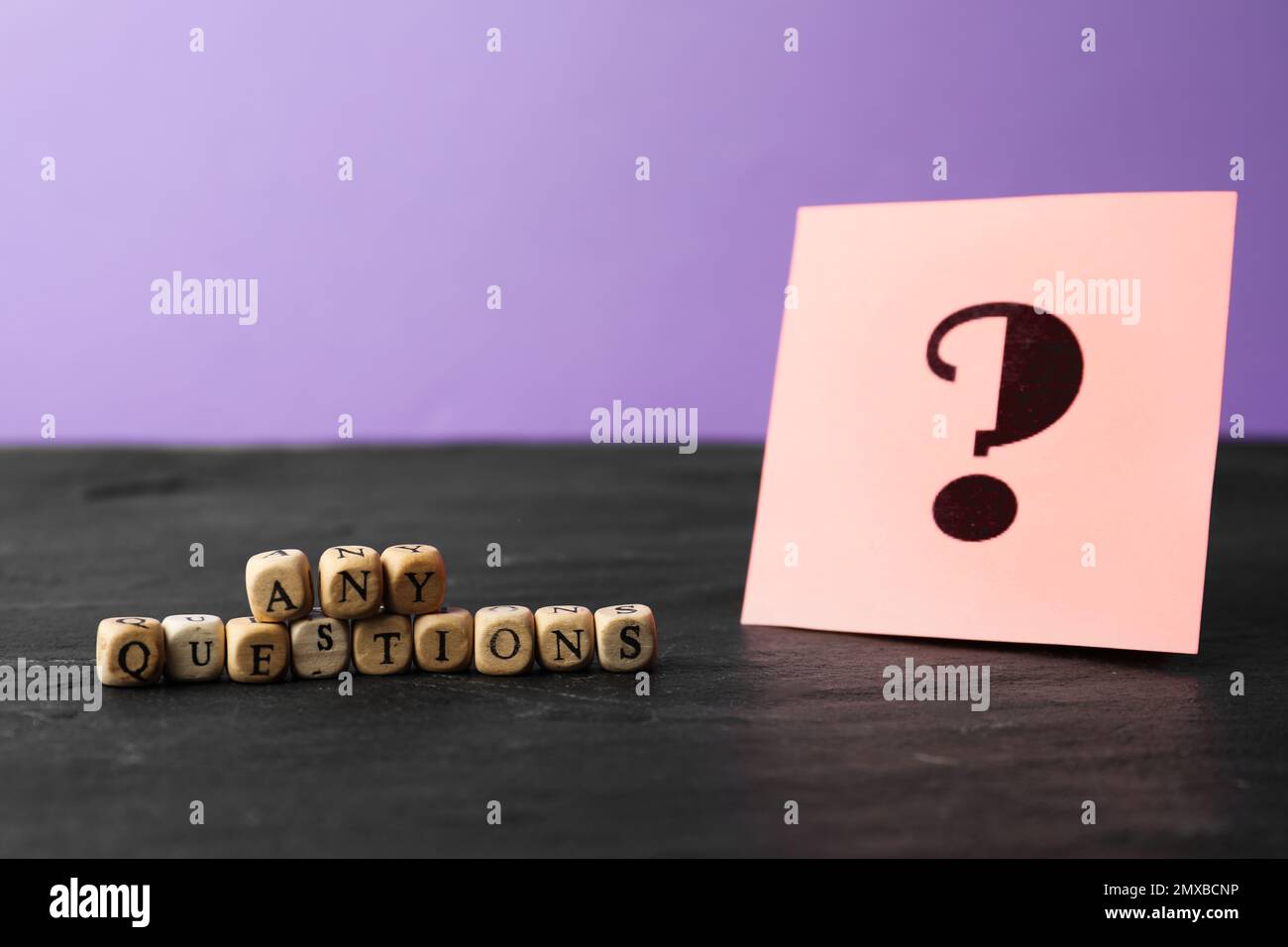 Phrase Any Questions made of wooden cubes and note with punctuation ...