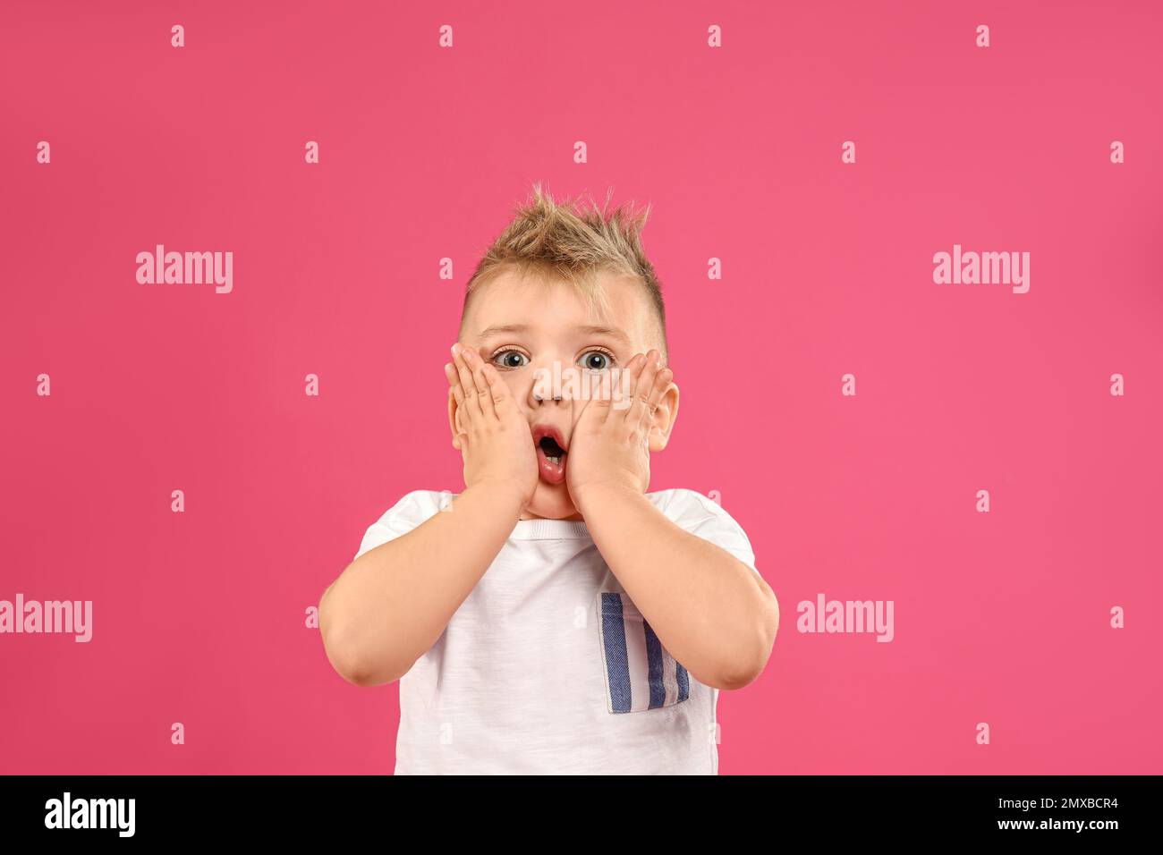 Cute little boy posing on pink background Stock Photo - Alamy