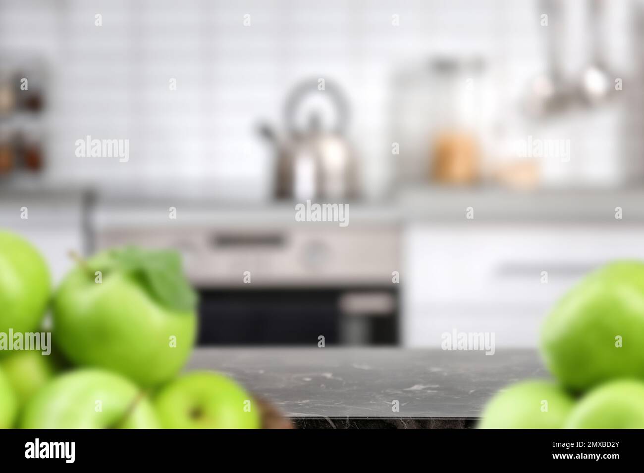 Dark table with apples in modern kitchen interior Stock Photo - Alamy