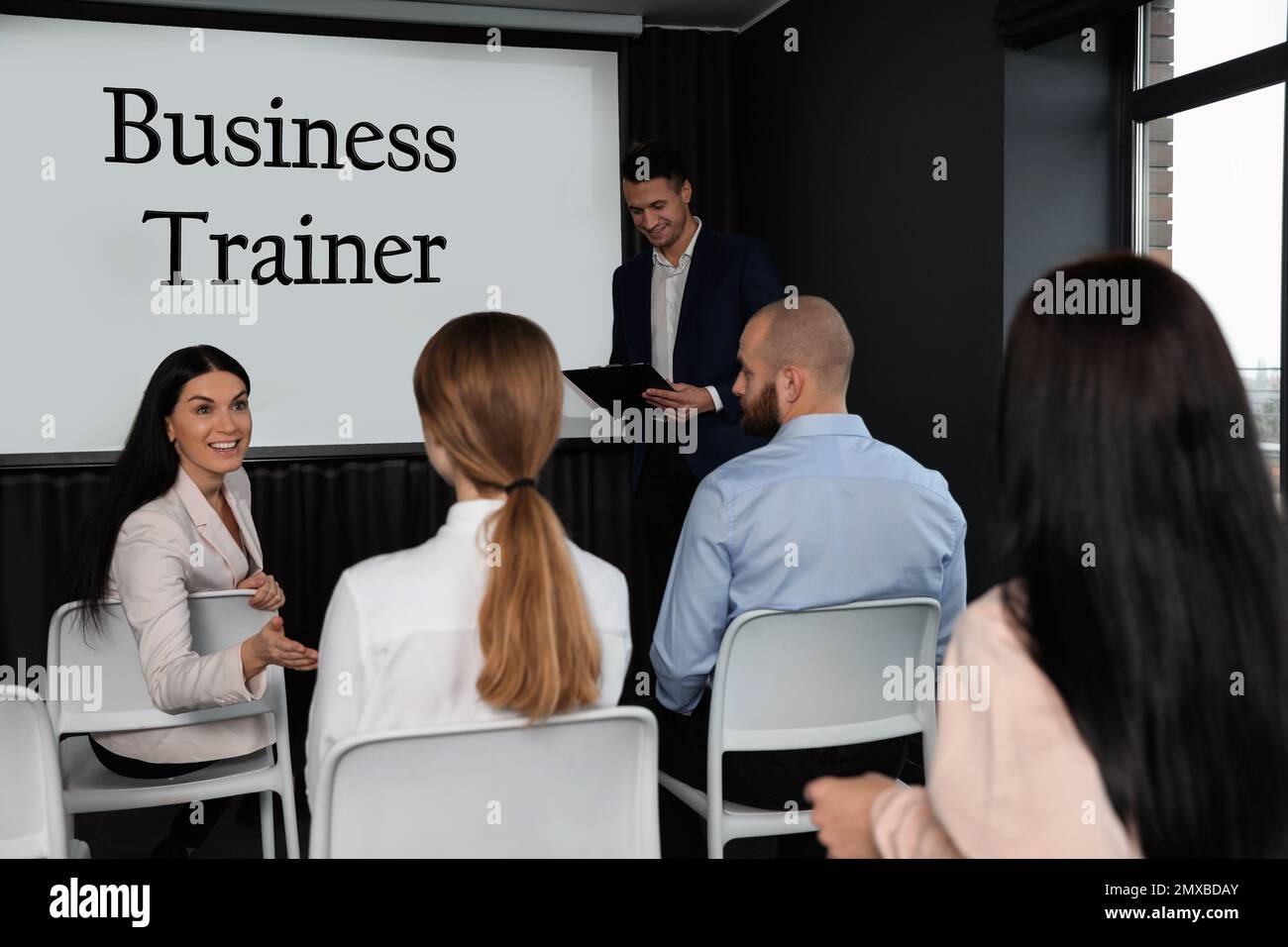 Professional business trainer and his students in conference room with ...