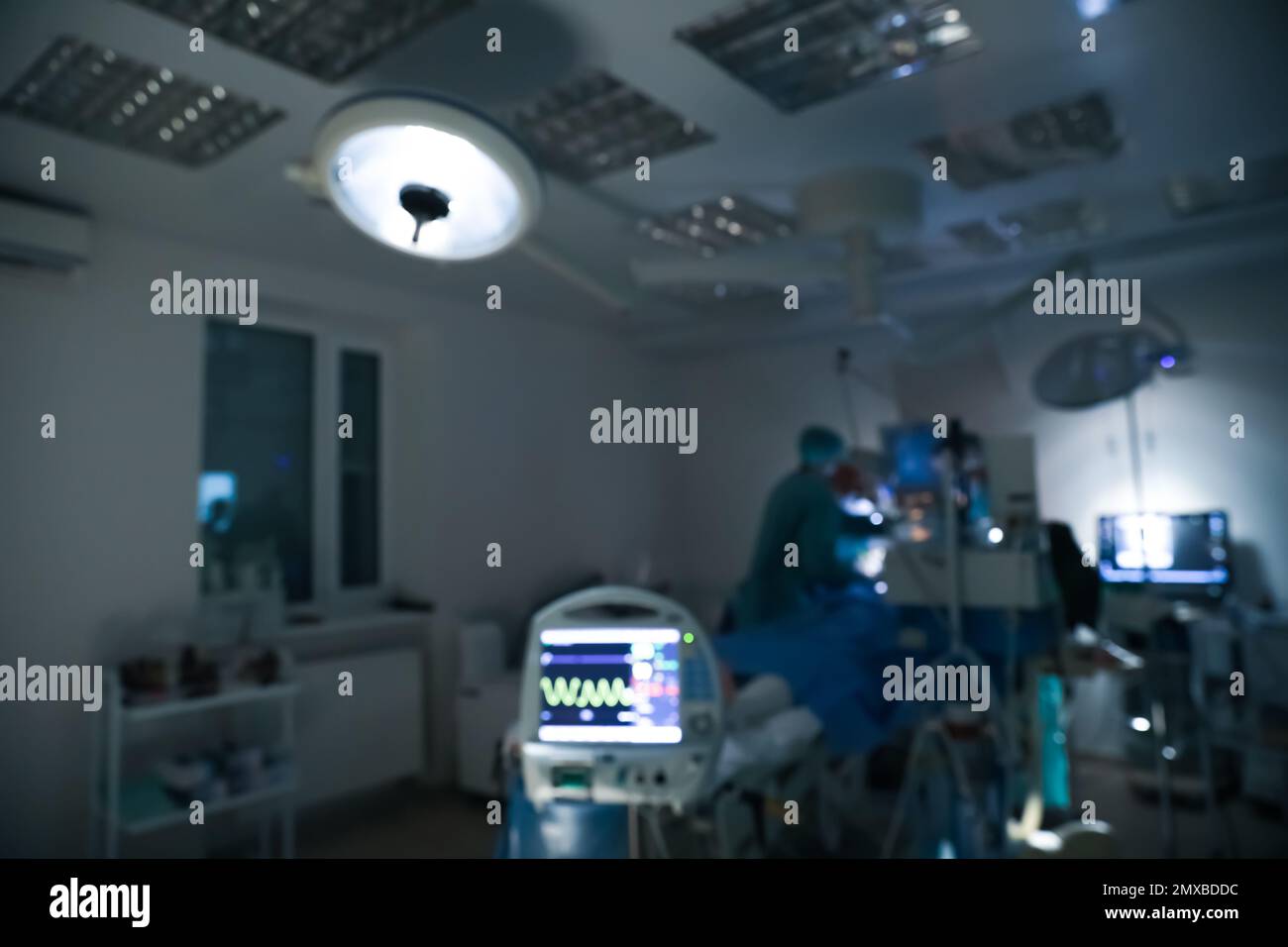 Blurred view of doctors operating patient in surgery room Stock Photo ...