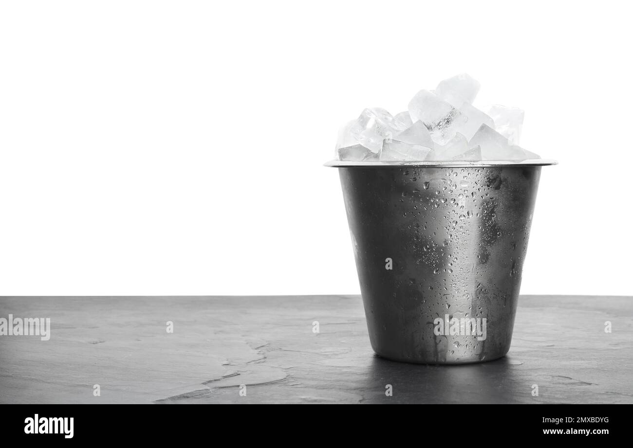 Metal bucket with ice cubes on table against white background Stock ...