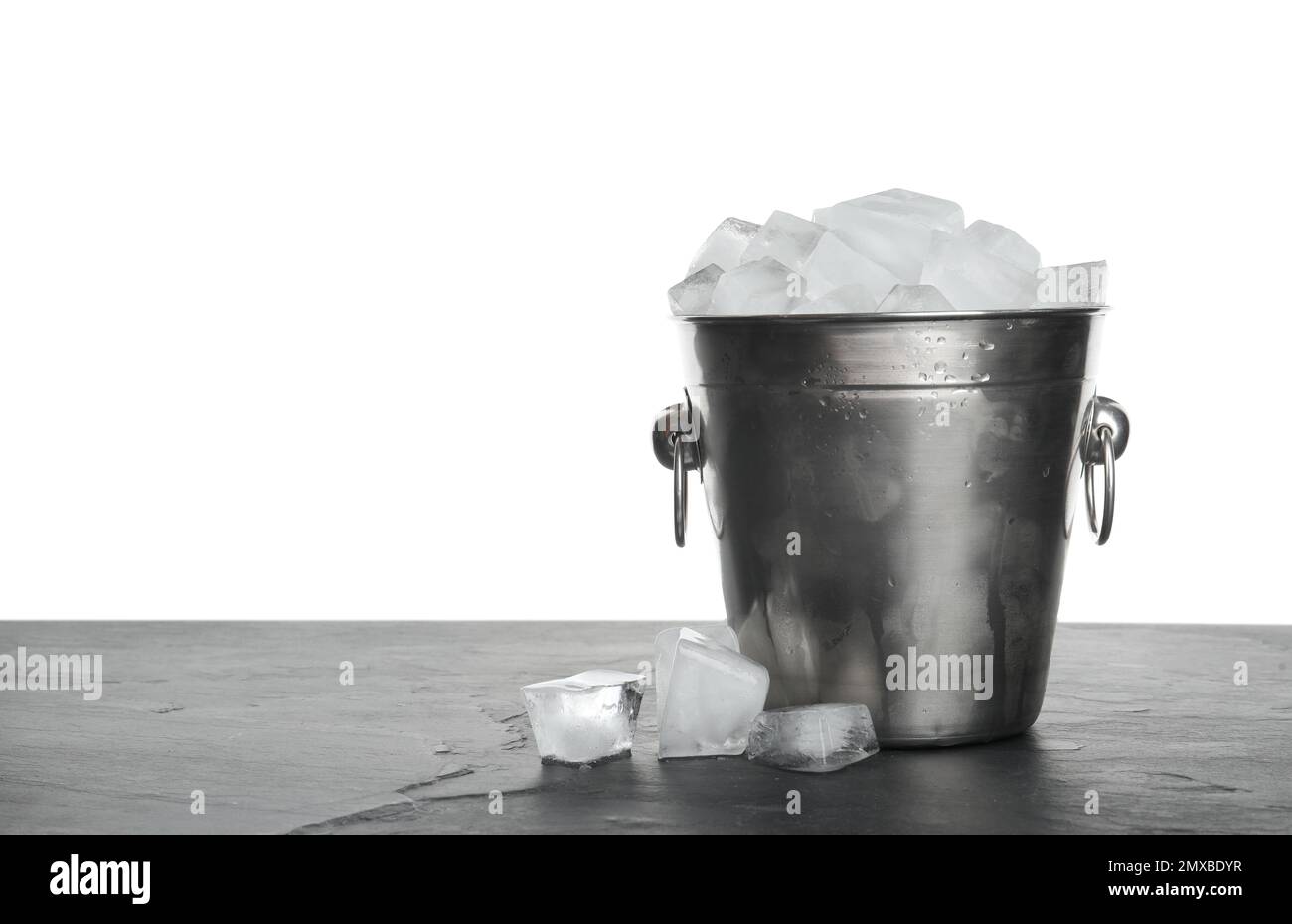 Metal bucket with ice cubes on table against white background Stock ...