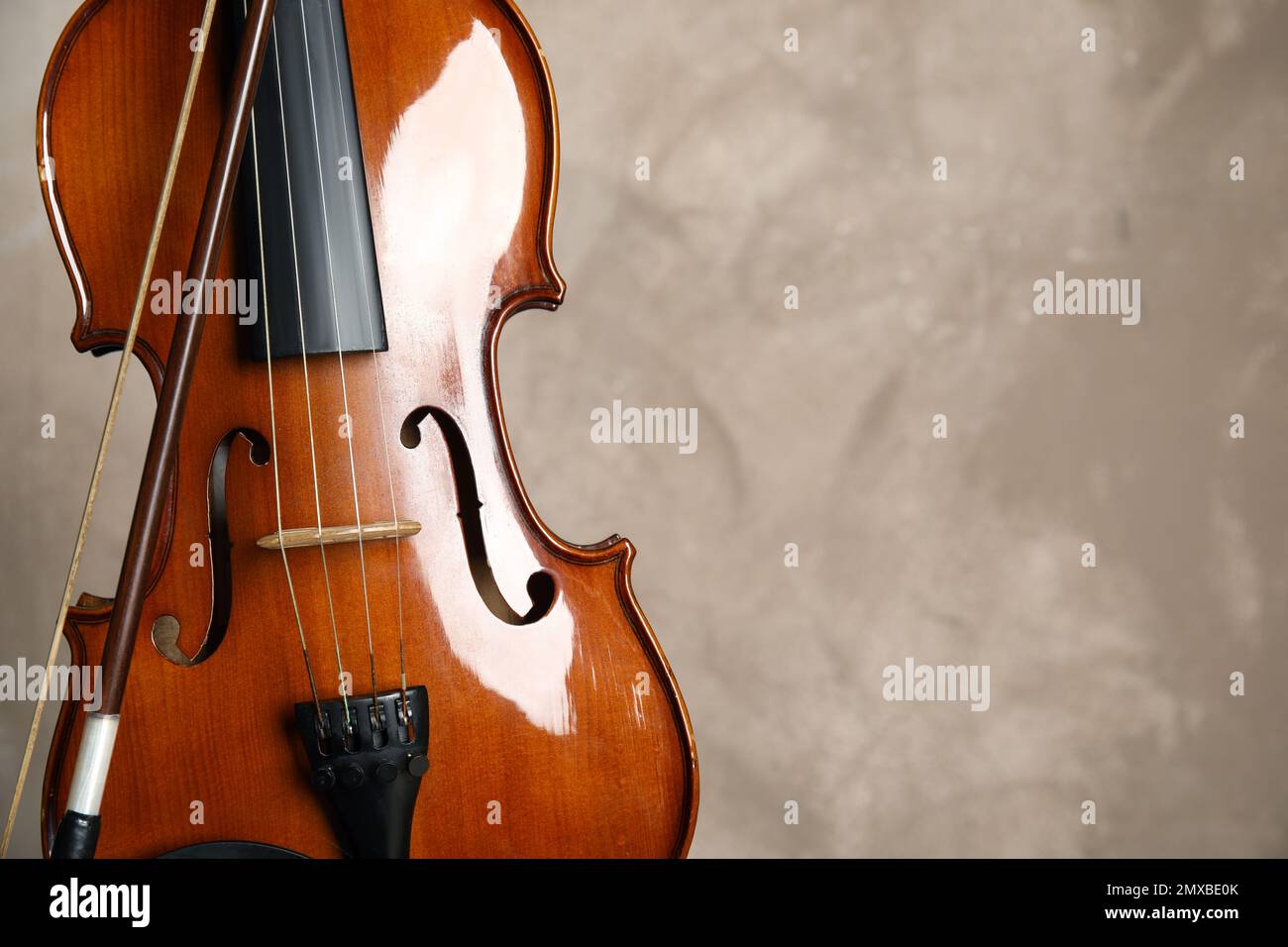 Classic violin and bow on beige background, closeup. Space for text ...