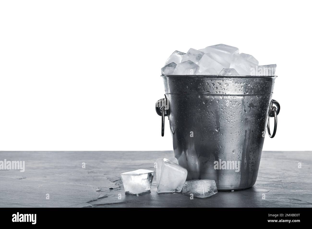 Metal bucket with ice cubes on table against white background Stock ...