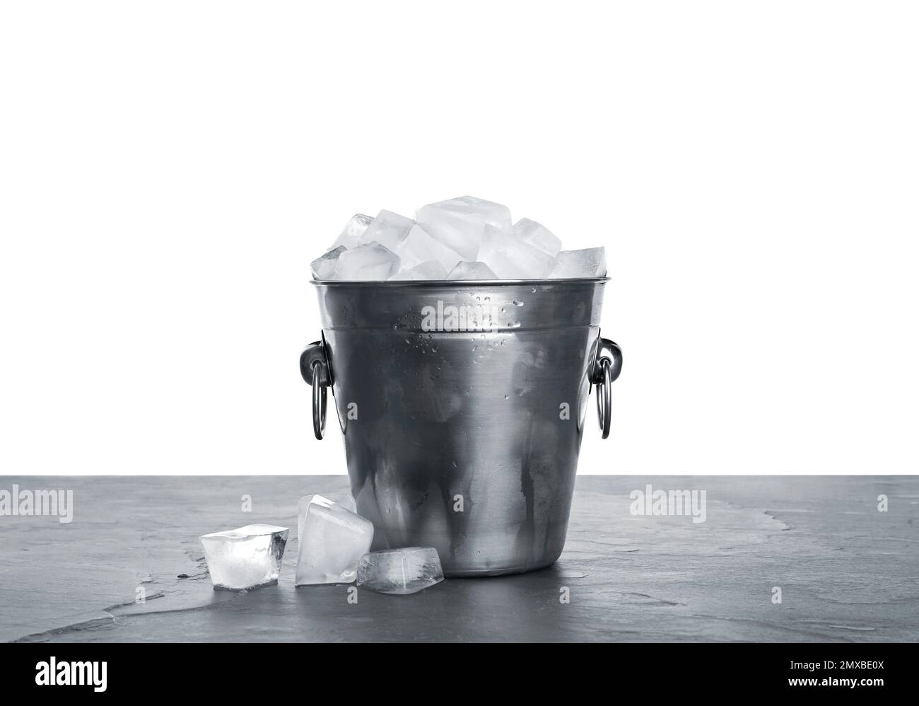 Metal bucket with ice cubes on table against white background Stock ...