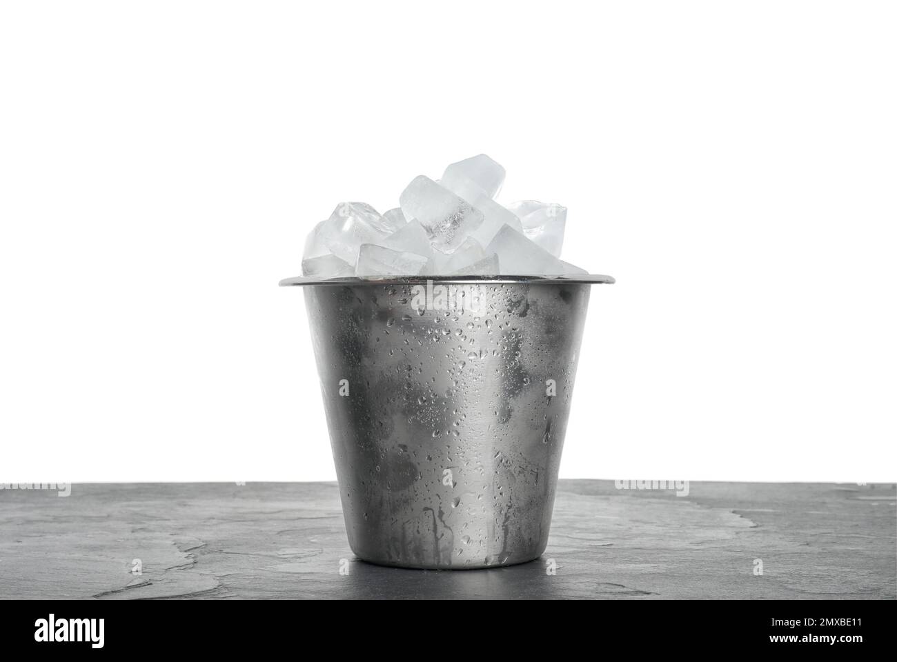Metal bucket with ice cubes on table against white background Stock ...