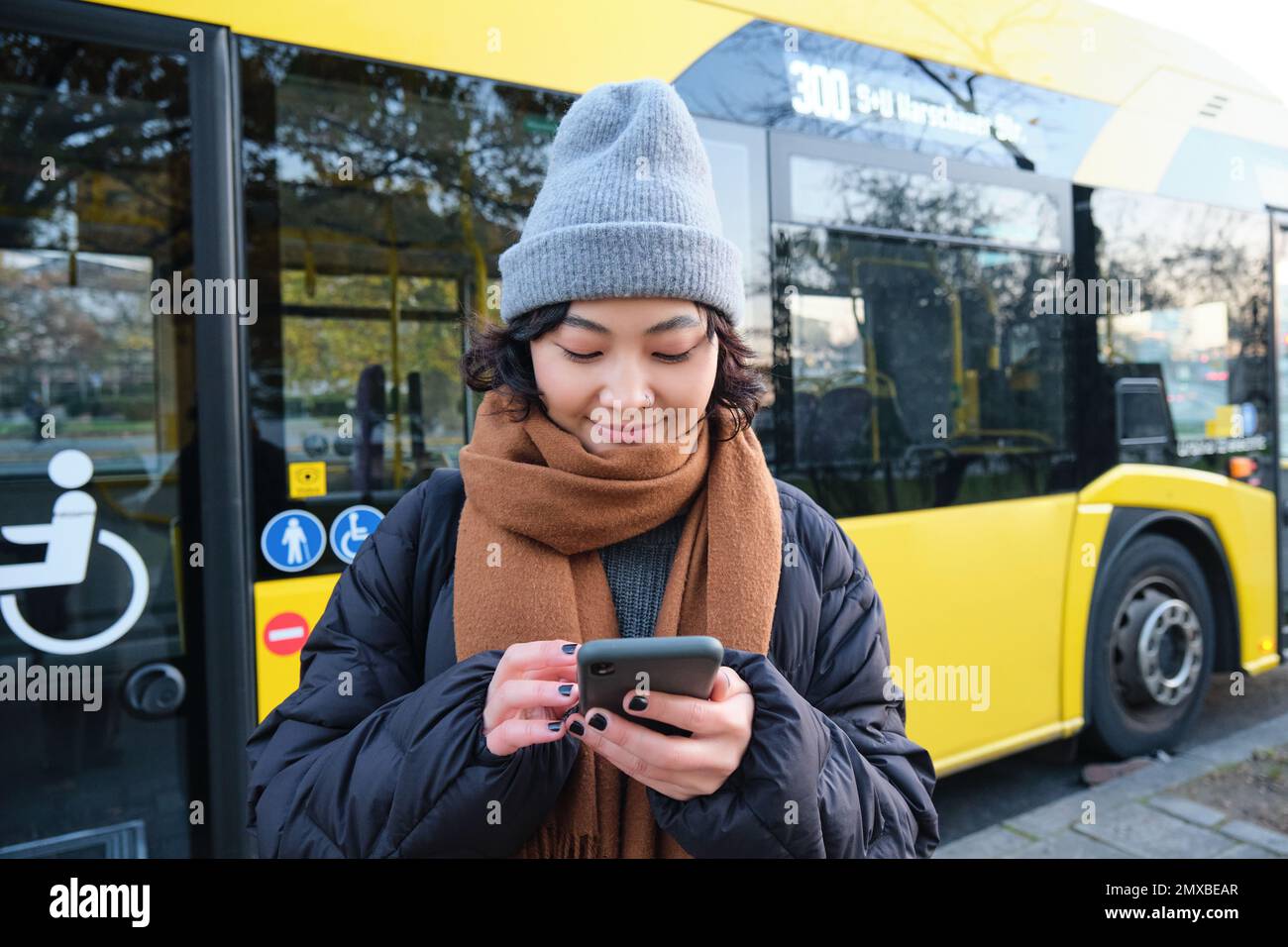 Image of girl student waiting for public transport, checks schedule on ...