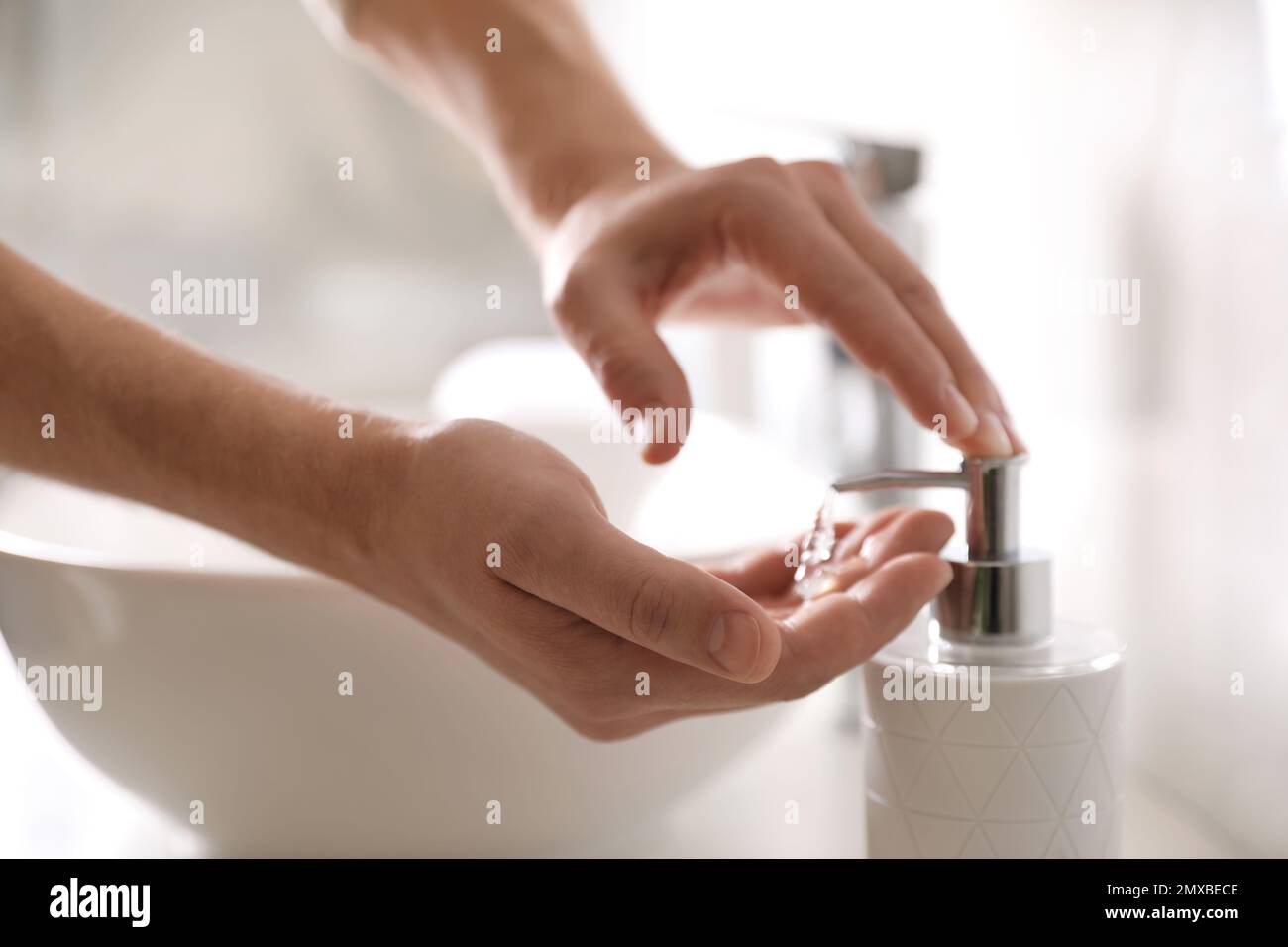 Man using soap dispenser in bathroom, closeup Stock Photo - Alamy