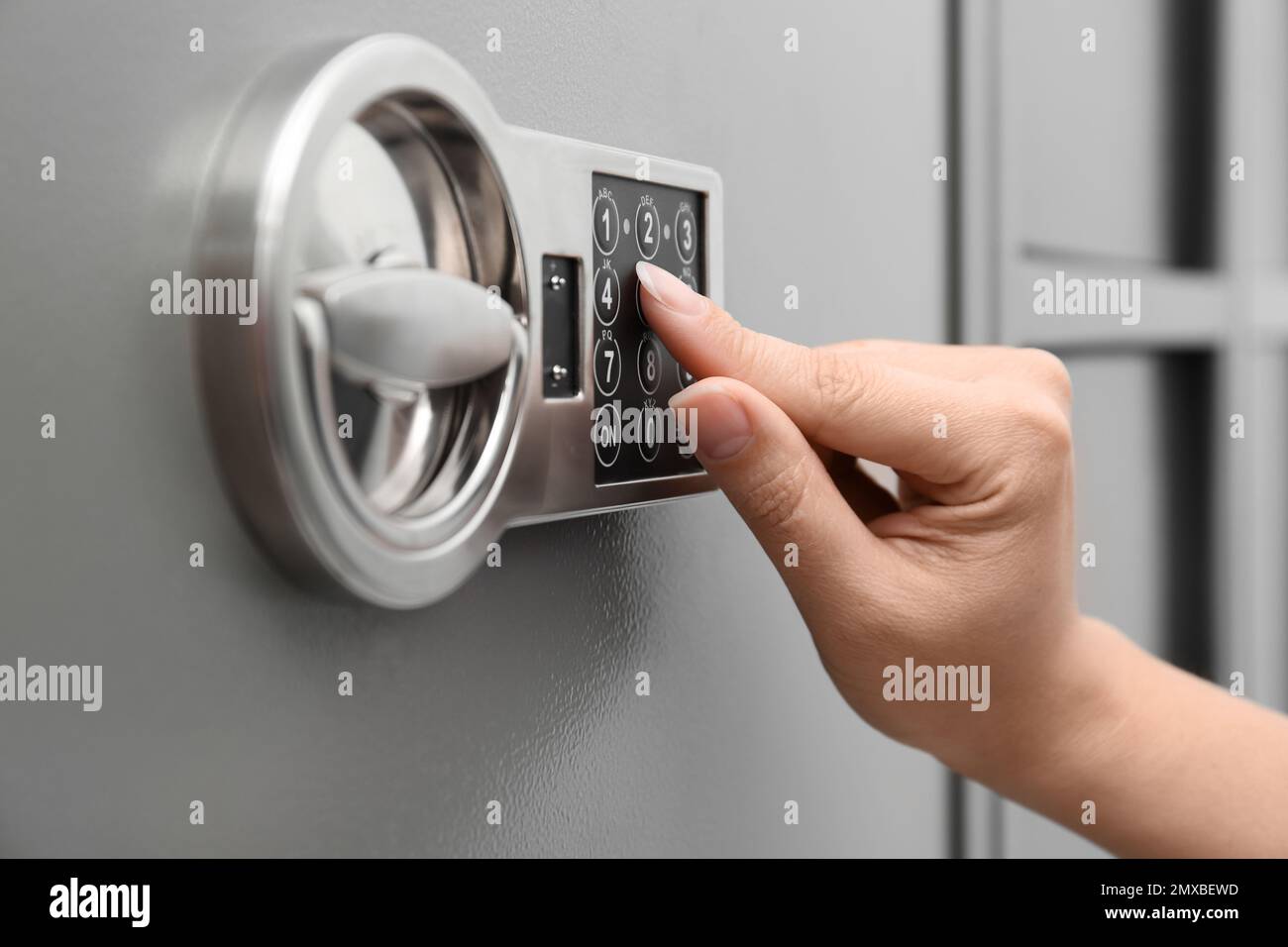 Woman entering code on keypad of modern safe, closeup Stock Photo - Alamy