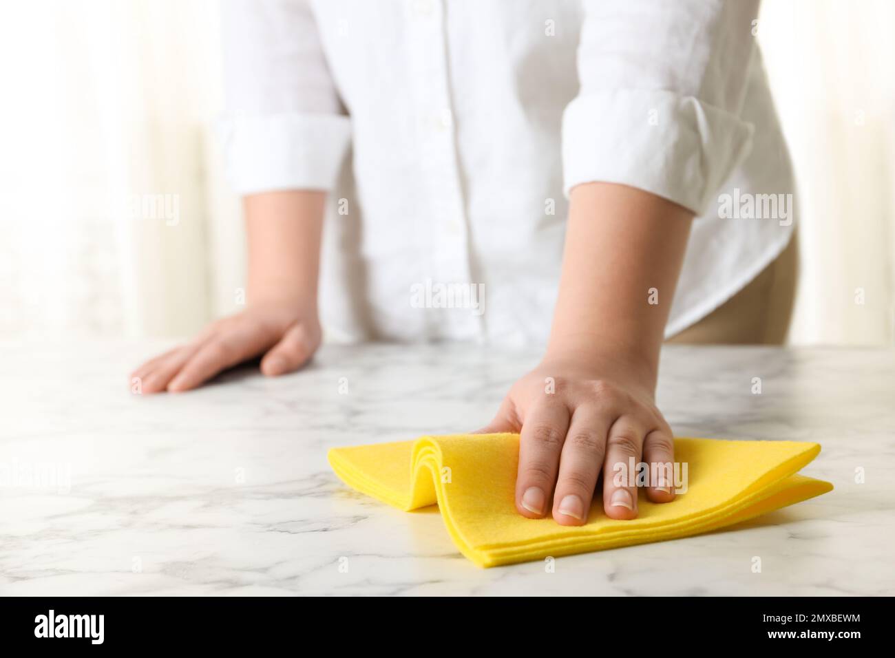 Woman wiping white marble table with rag indoors, closeup Stock Photo ...