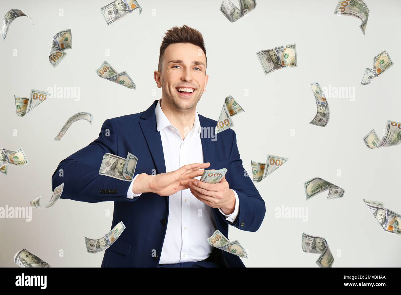Man throwing American dollars on light grey background Stock Photo - Alamy