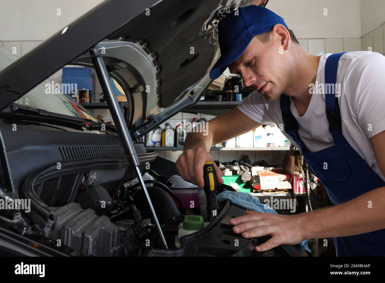 Professional auto mechanic fixing modern car in service center Stock ...