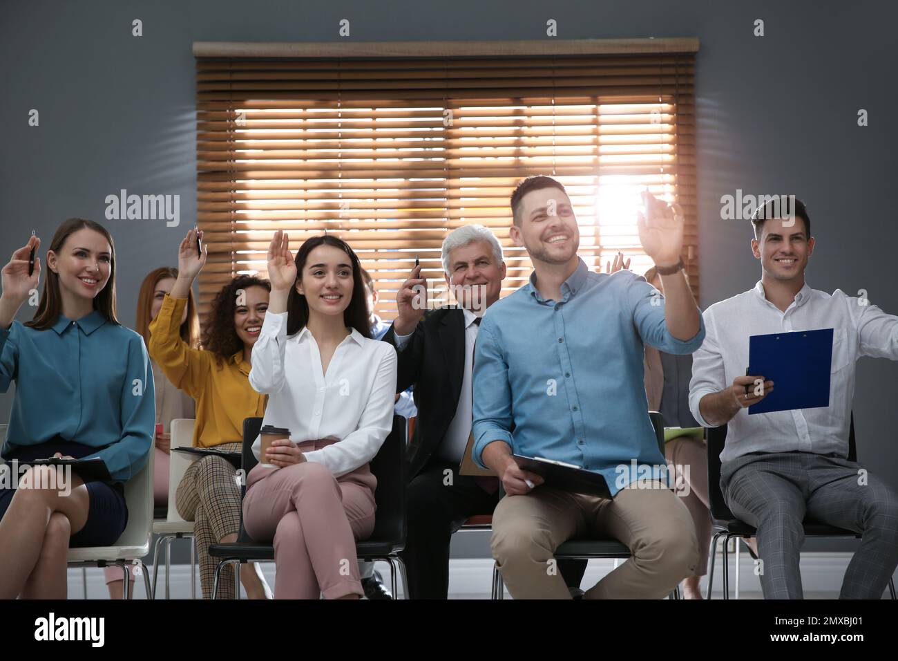 People raising hands to ask questions at seminar in office Stock Photo ...