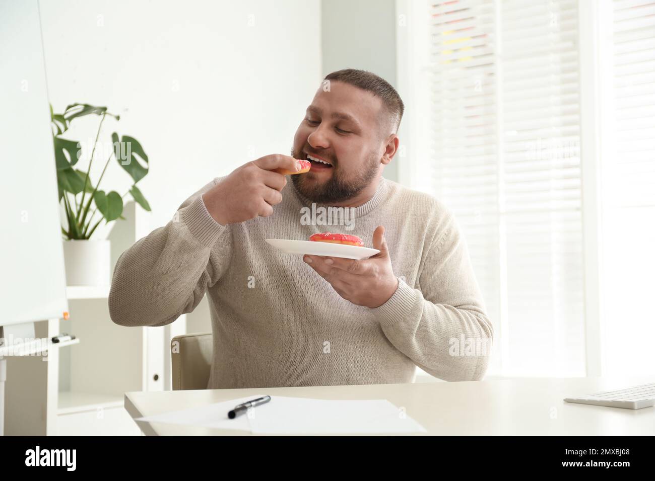 Lazy overweight office employee with donuts at workplace Stock Photo ... Lazy overweight office employee with donuts at workplace Stock Photo ...