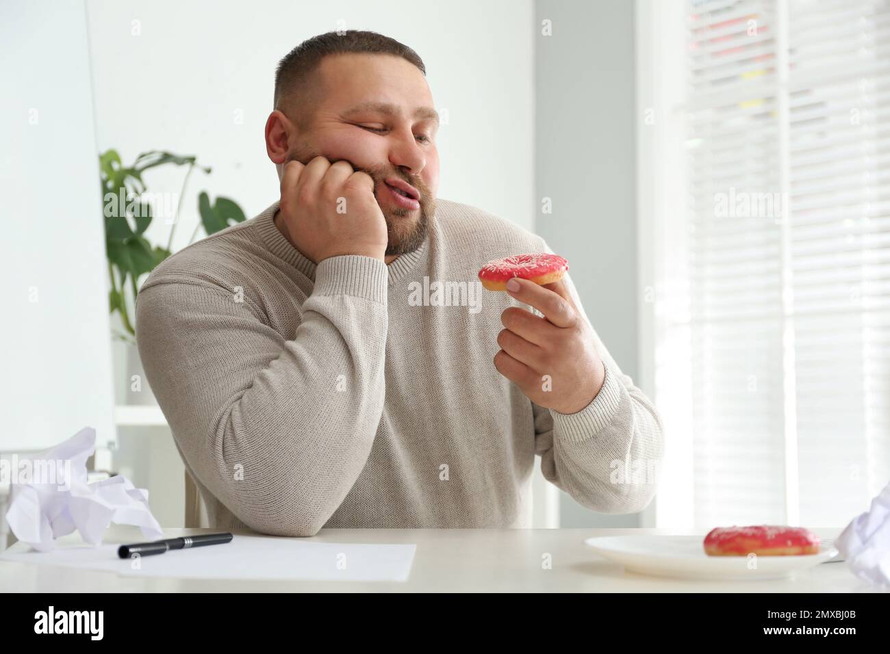 Lazy overweight office employee with donut at workplace Stock Photo - Alamy