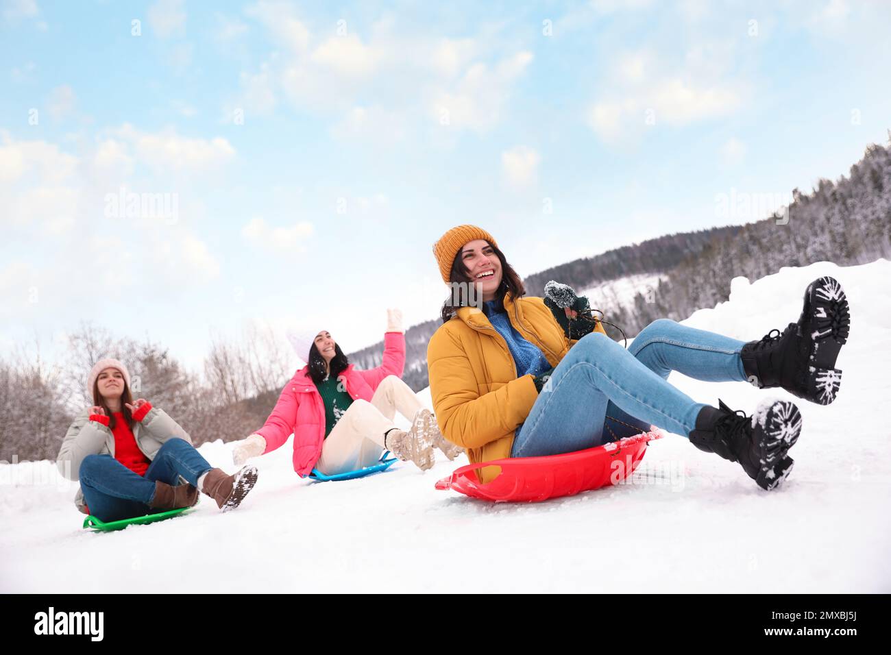 Group of friends having fun and sledding on snow. Winter vacation Stock ...