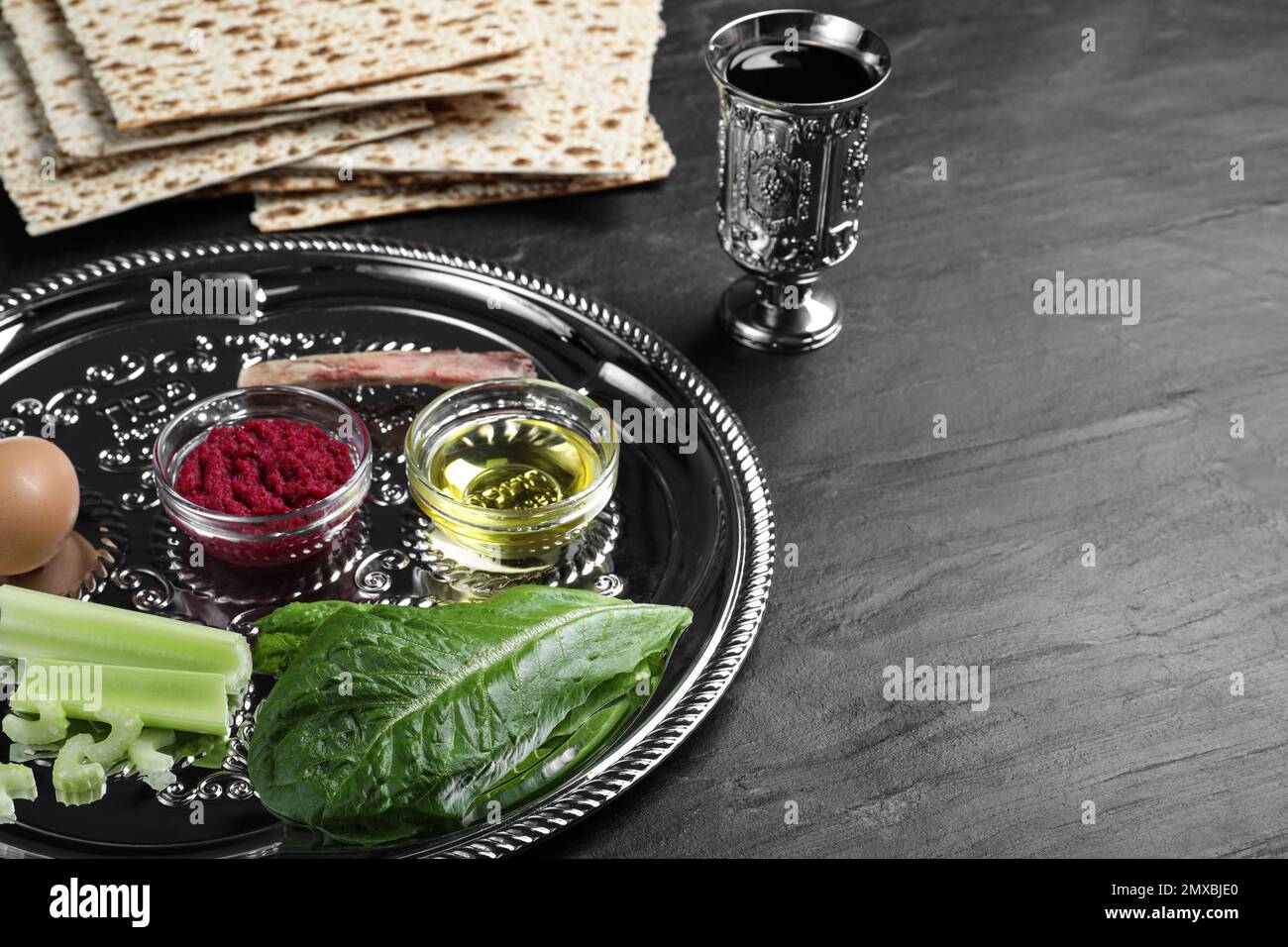 Passover Seder plate (keara) with traditional meal on black table ...