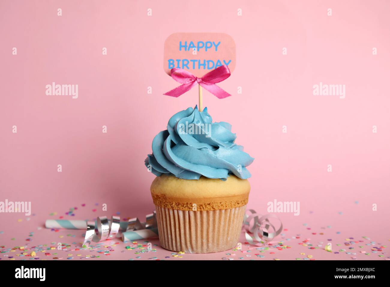 Beautiful birthday cupcake, streamers and confetti on pink background ...