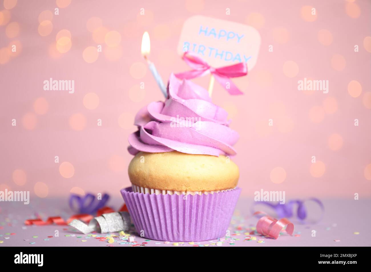 Beautiful birthday cupcake, streamers and confetti against pink ...