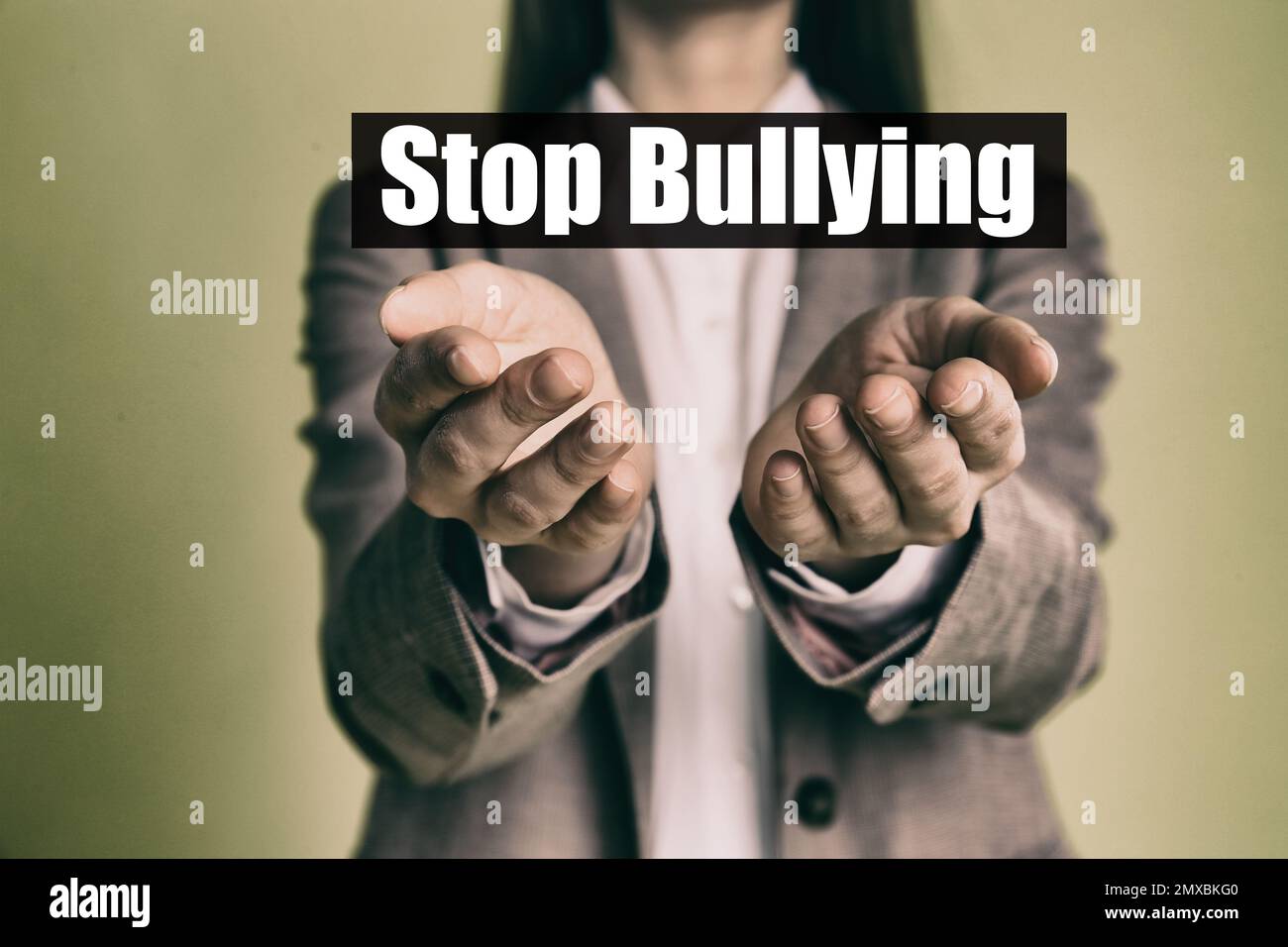 Young woman showing sign STOP BULLYING on color background, closeup ...