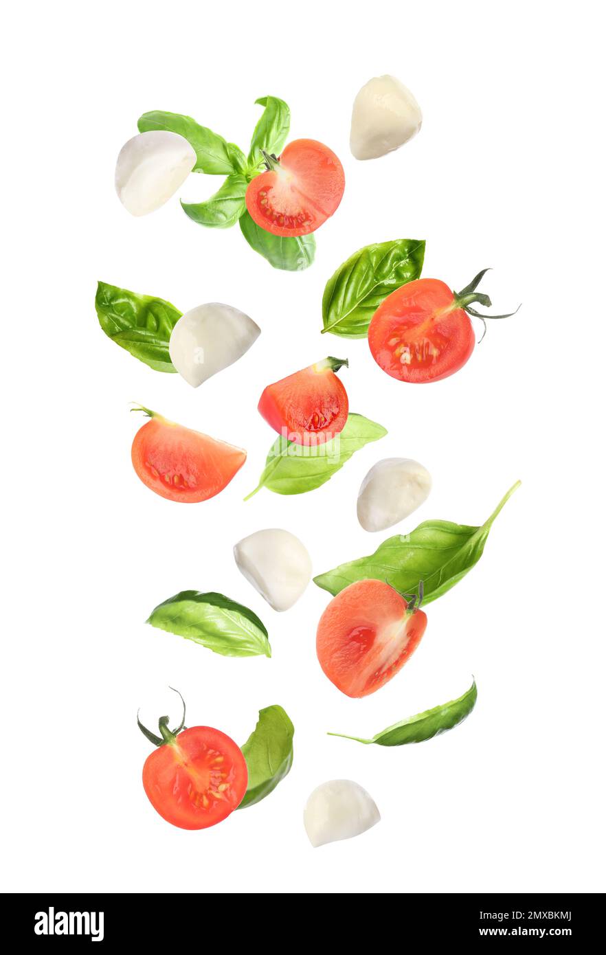 Mozzarella cheese balls, tomatoes and basil leaves falling on white ...