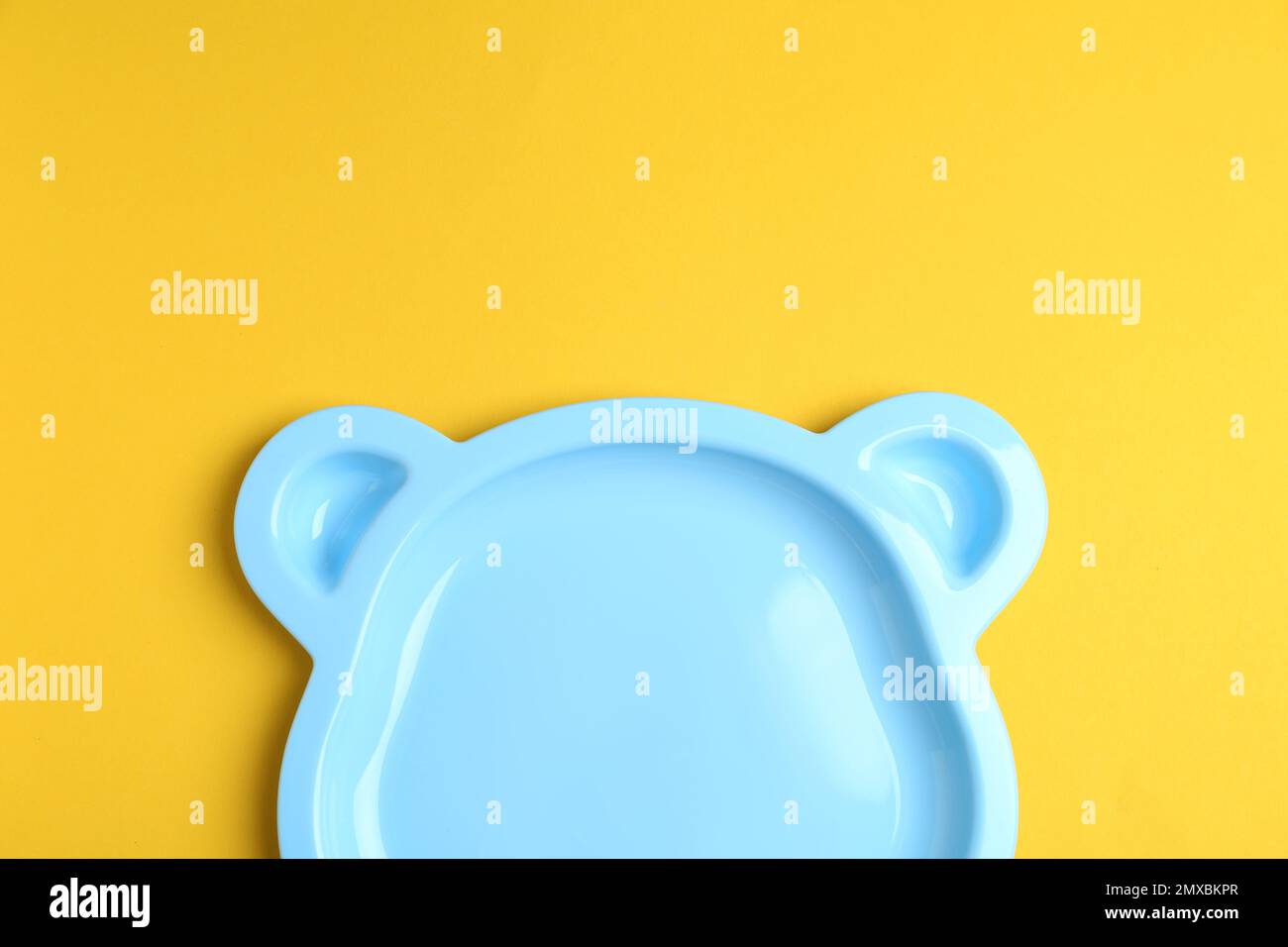 Cute animal shaped plate on yellow background, top view. Serving baby ...