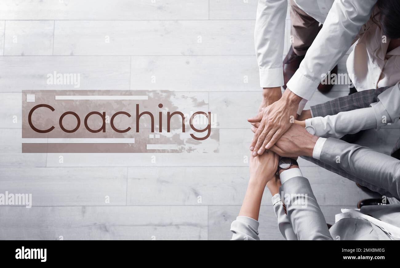 Adult learning. Word Coaching and people holding hands together over ...