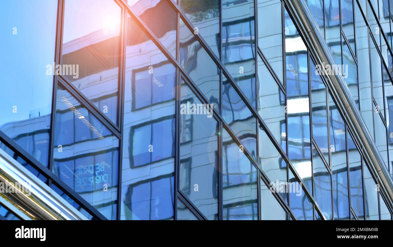 Modern glass facade against blue sky. Bottom view of a building in the ...