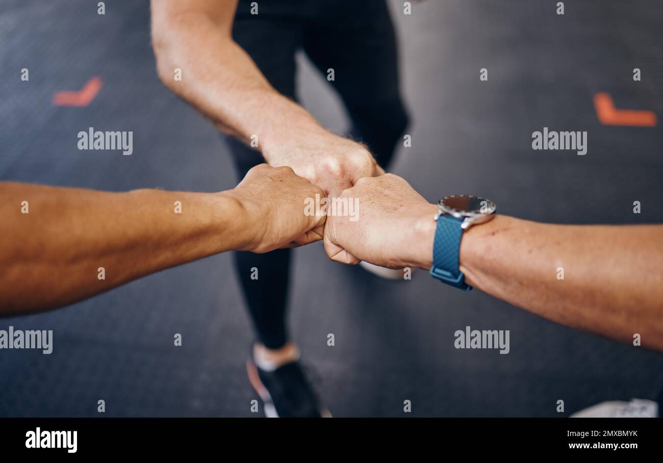 Group fist bump, hands and gym for motivation with personal trainer for ...
