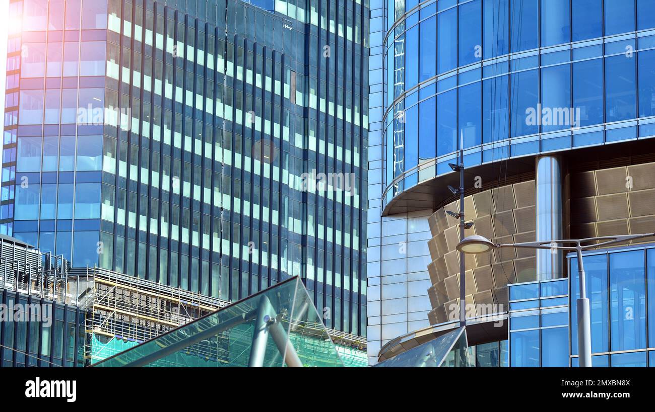 Modern glass facade against blue sky. Bottom view of a building in the ...